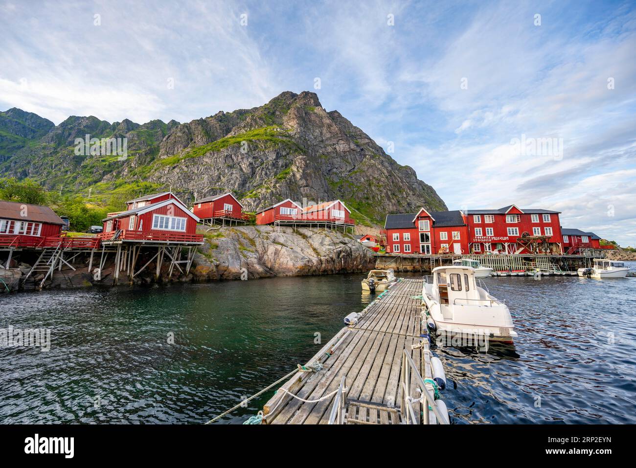 Traditional red rorbuer wooden cabins, on stilts on the shore, fishing ...