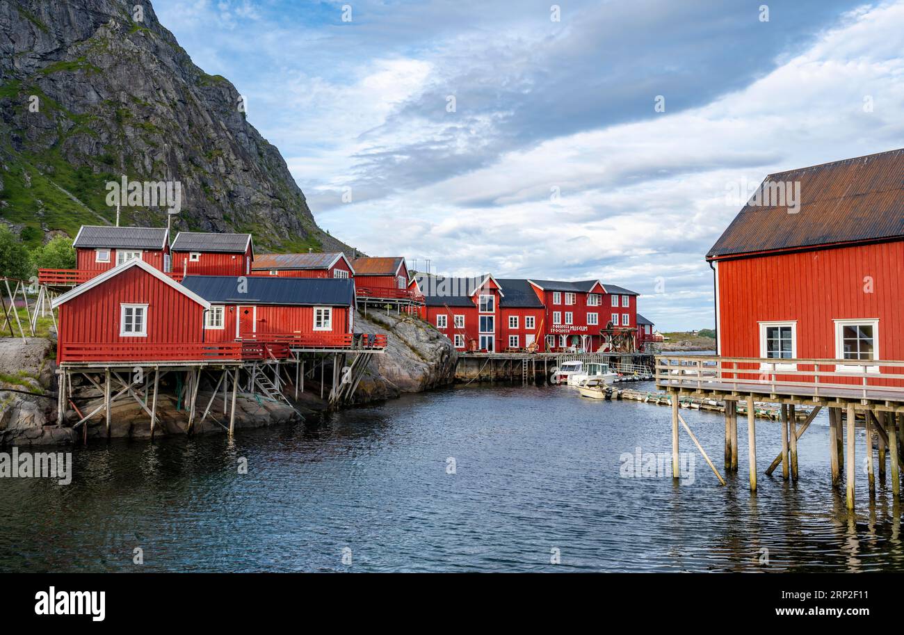 Traditional red rorbuer wooden cabins, on stilts on the shore, fishing ...