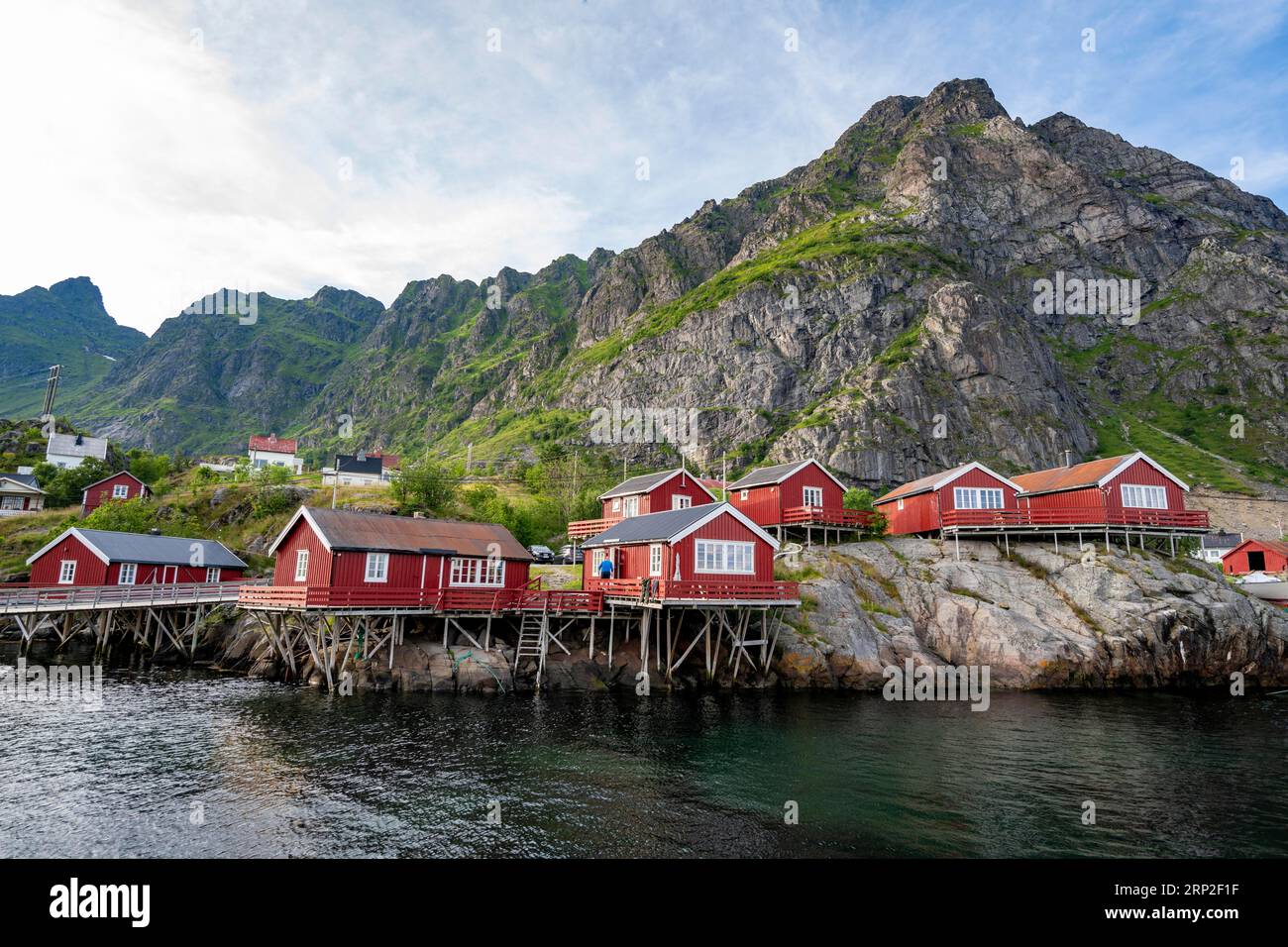 Traditional red rorbuer wooden cabins, on stilts on the shore, fishing ...