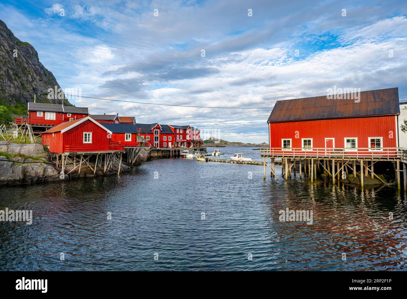 Traditional red rorbuer wooden cabins, on stilts on the shore, fishing ...