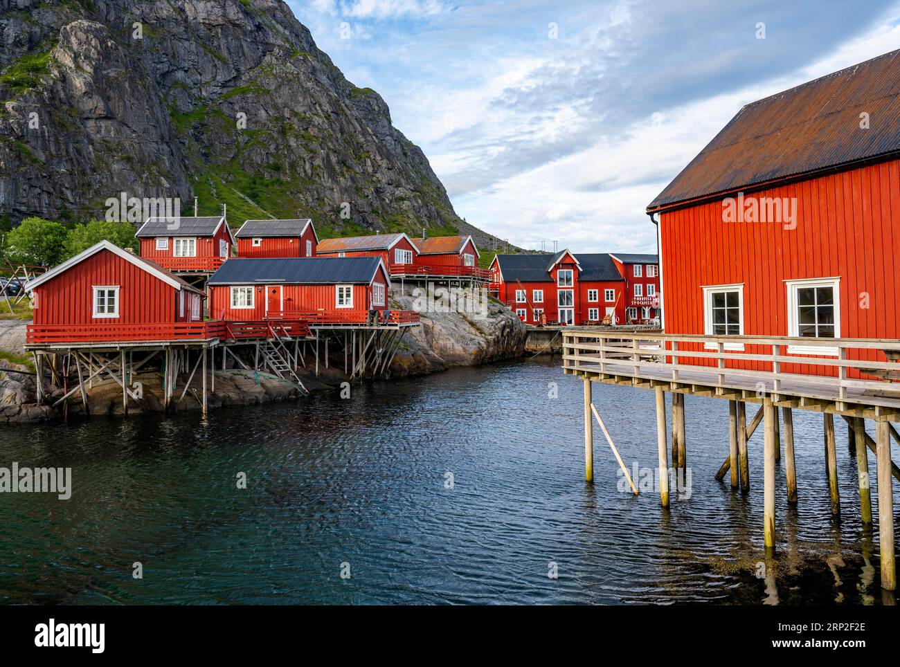 Traditional red rorbuer wooden cabins, on stilts on the shore, fishing ...