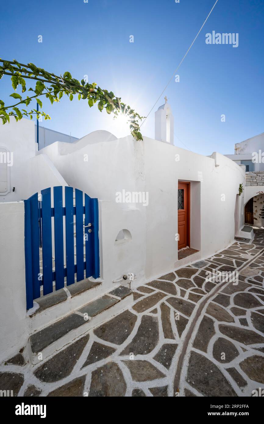 White Cycladic houses with blue doors, alleys of the village of ...