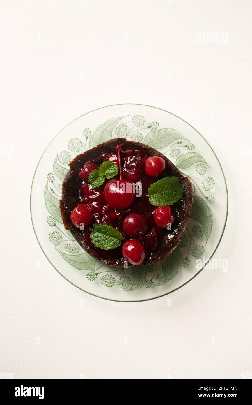 Delicious chocolate dessert with lingonberry jam, cherries and mint on ...