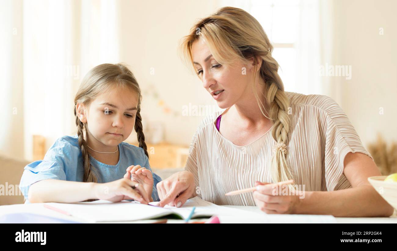 Mother helping her daughter her homework Stock Photo - Alamy