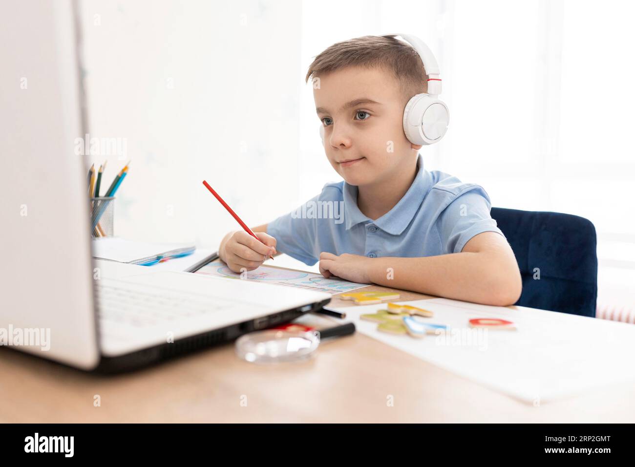 Medium shot kid holding pencil Stock Photo - Alamy