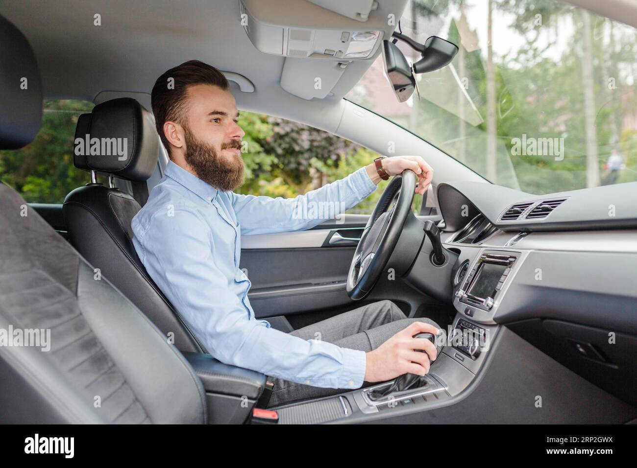 Side view young man riding car Stock Photo - Alamy