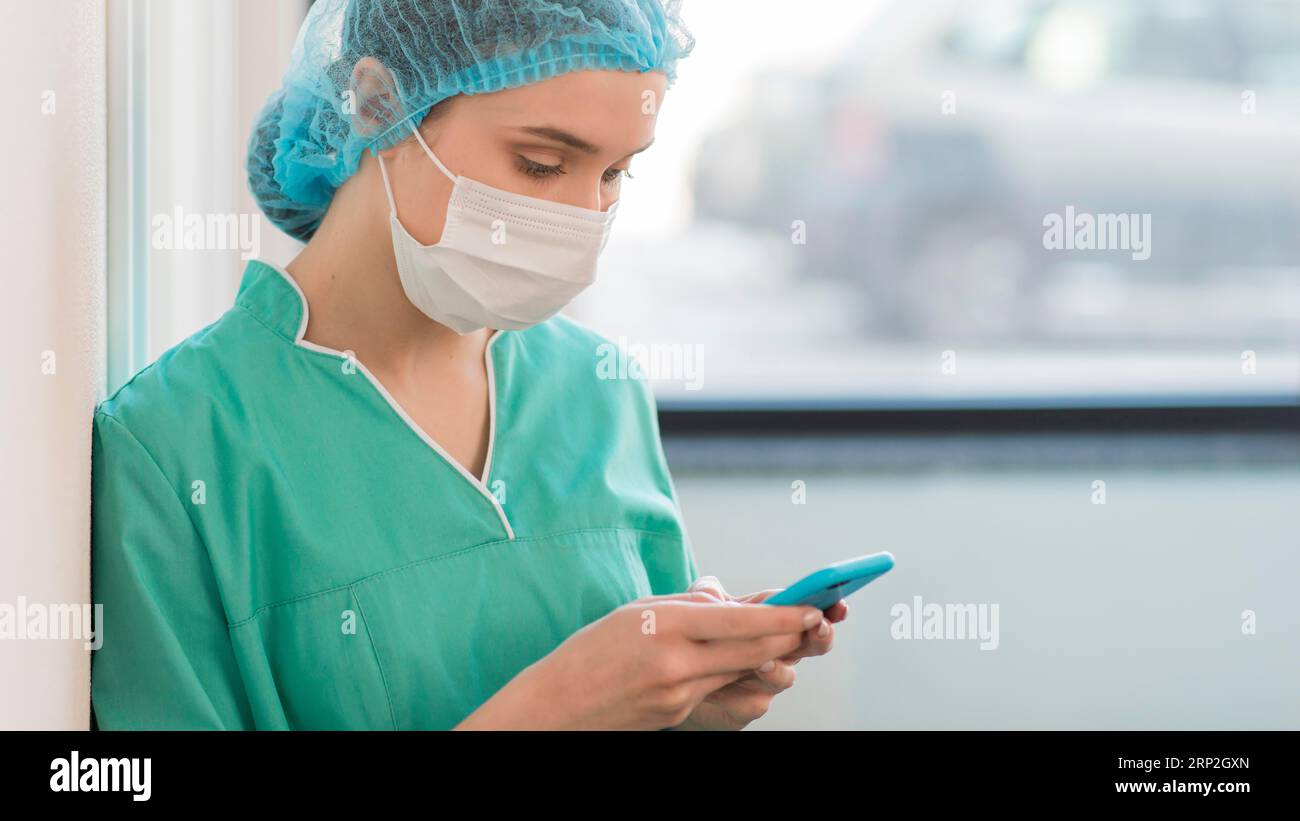 Side view nurse with mask checking mobile Stock Photo - Alamy