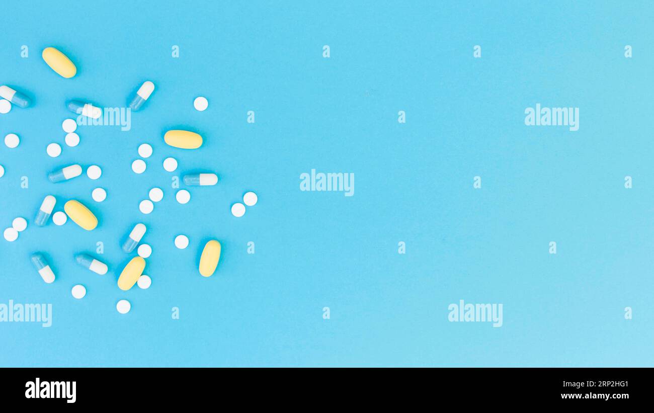 Top view medical pills capsules blue background Stock Photo - Alamy
