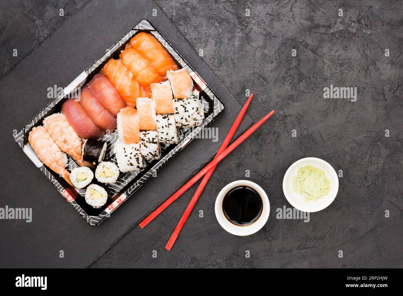 Vivid asian fish rolls tray chopsticks with soya sauce wasabi back ...