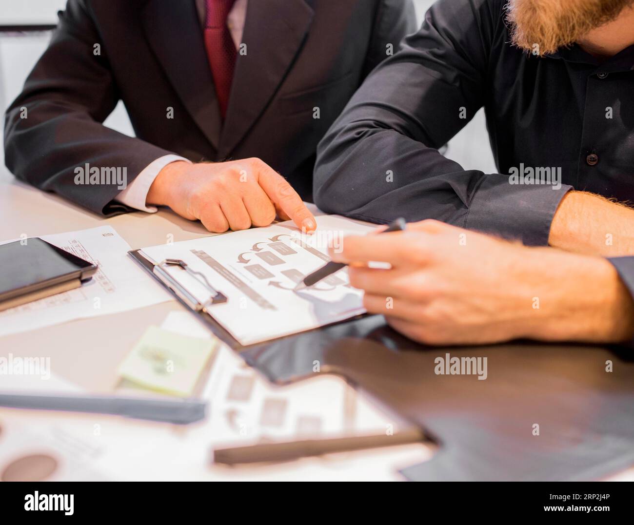 Close up two businessmen pointing business chart meeting Stock Photo ...