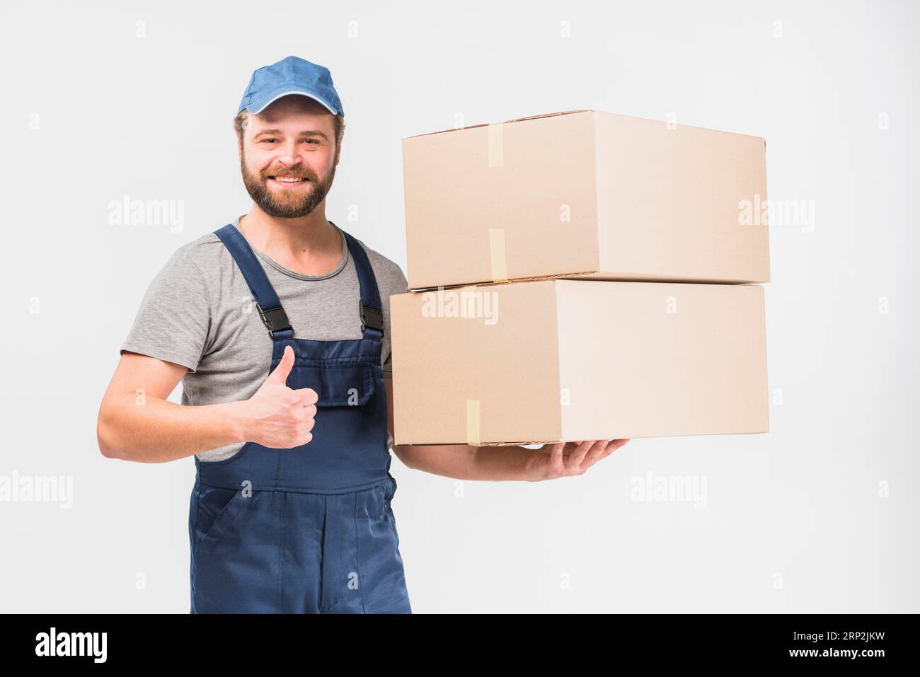 Delivery man with boxes showing thumb up Stock Photo - Alamy