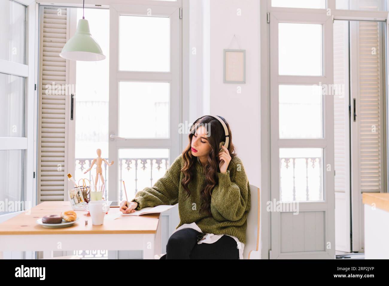 Focused woman drawing listening music Stock Photo - Alamy