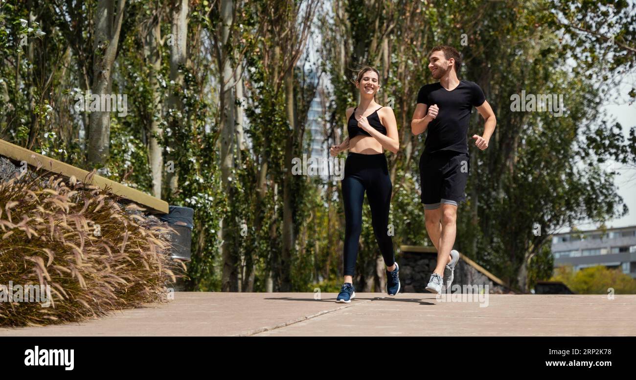 Front view man woman jogging together outdoors Stock Photo - Alamy