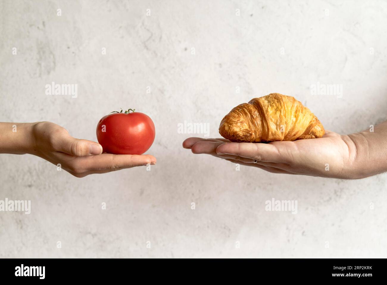 Human hand showing croissant red tomato front concrete background Stock ...