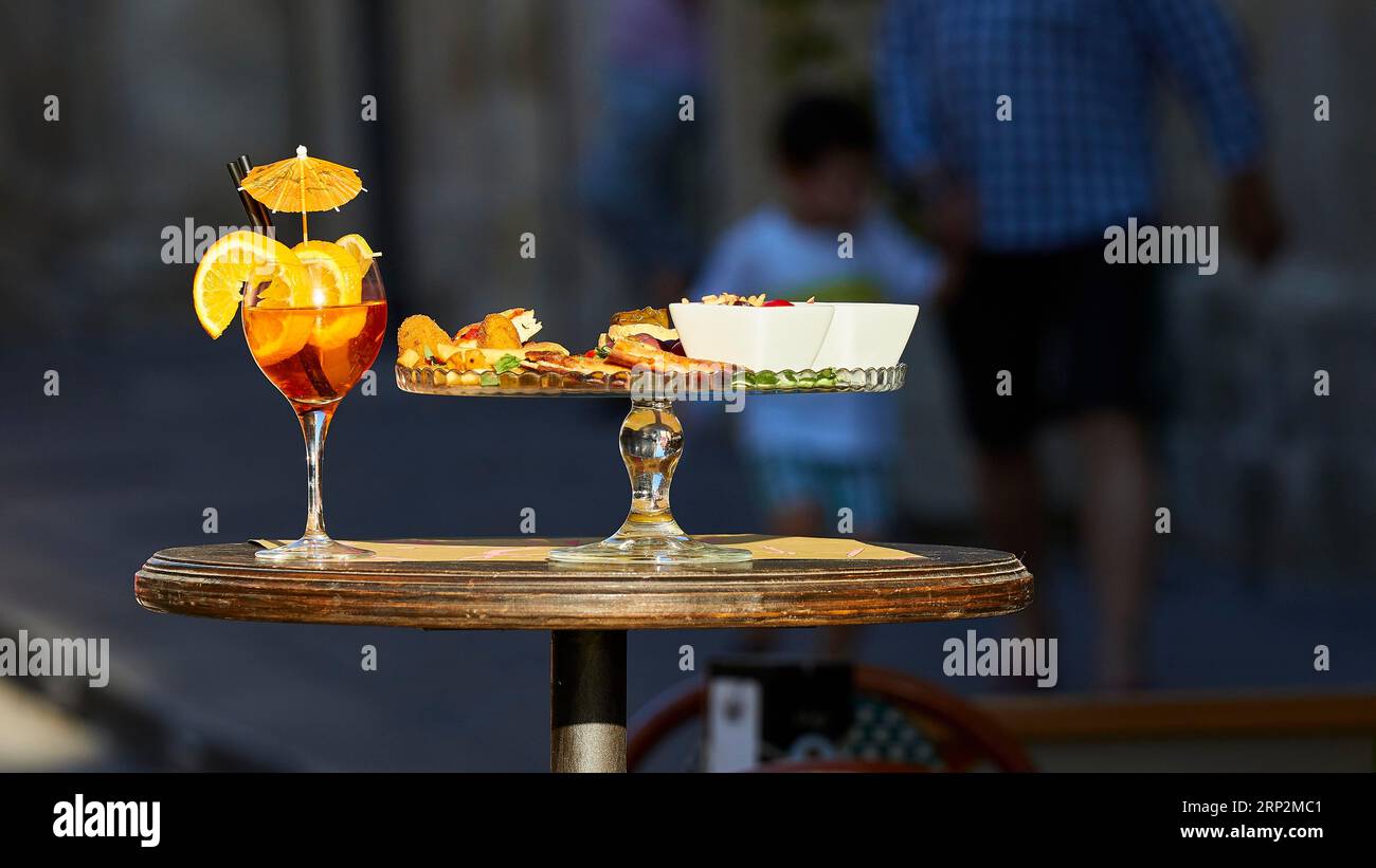Cocktail glass, glass bowl with pastry, back light, evening light ...