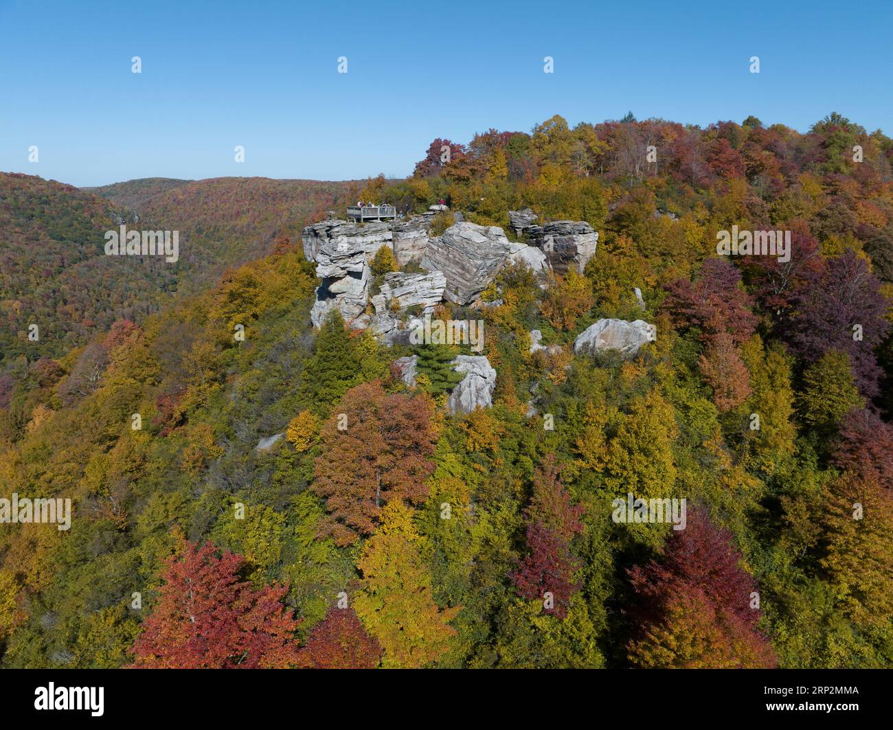 An autumnal landscape of rolling hills and mountains, dotted with ...