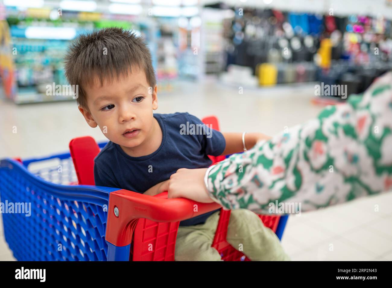 Two year old adorable multiracial toddler in a blue t-shirt sitting in ...