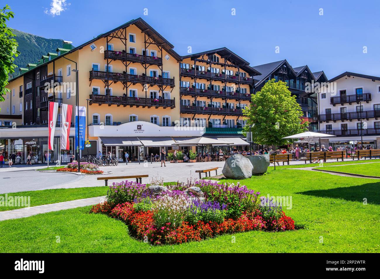 Flower border on the village square with hotels, Seefeld, Tyrol ...