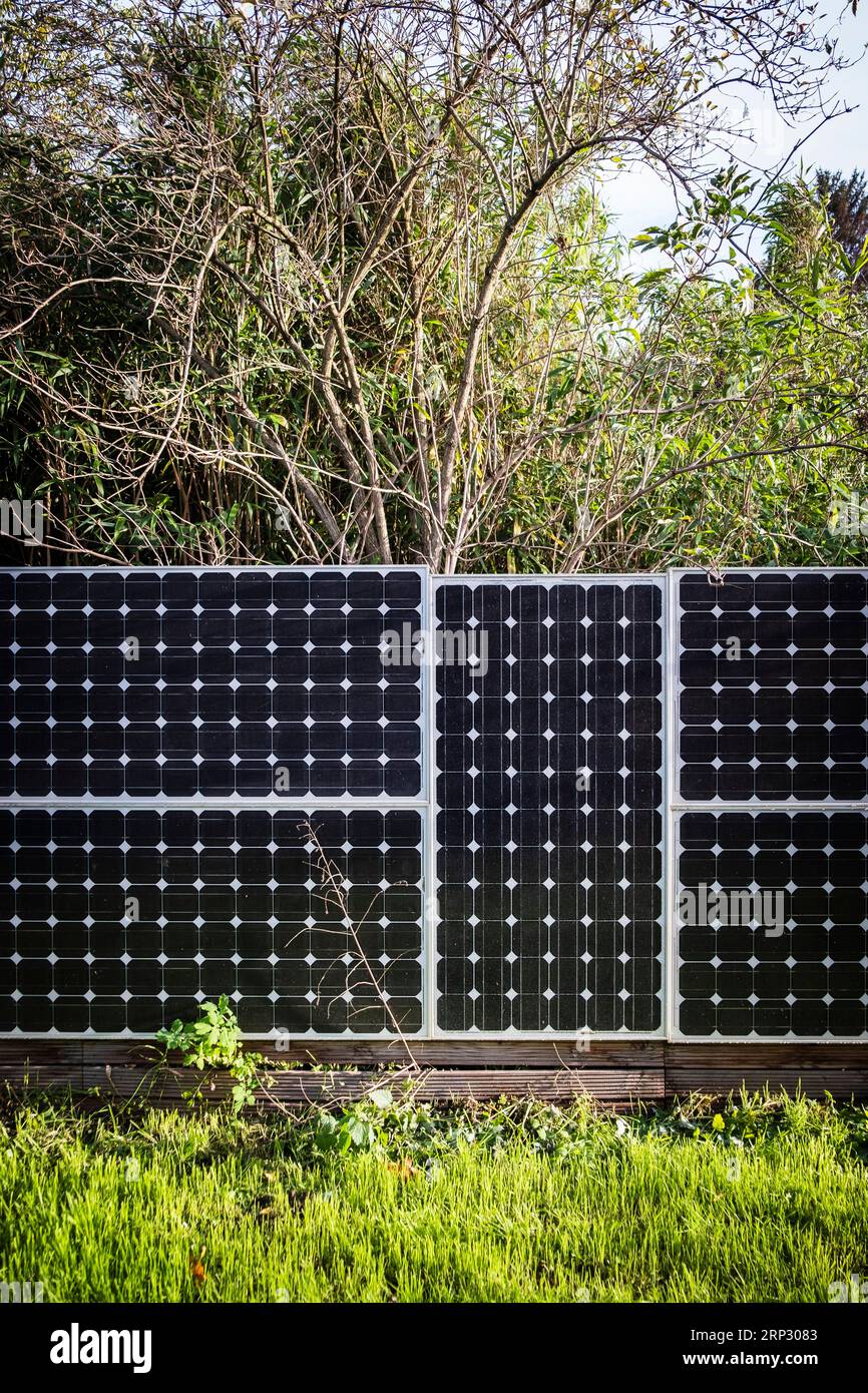 Solar panels as a garden fence and privacy screen of a house on a ...