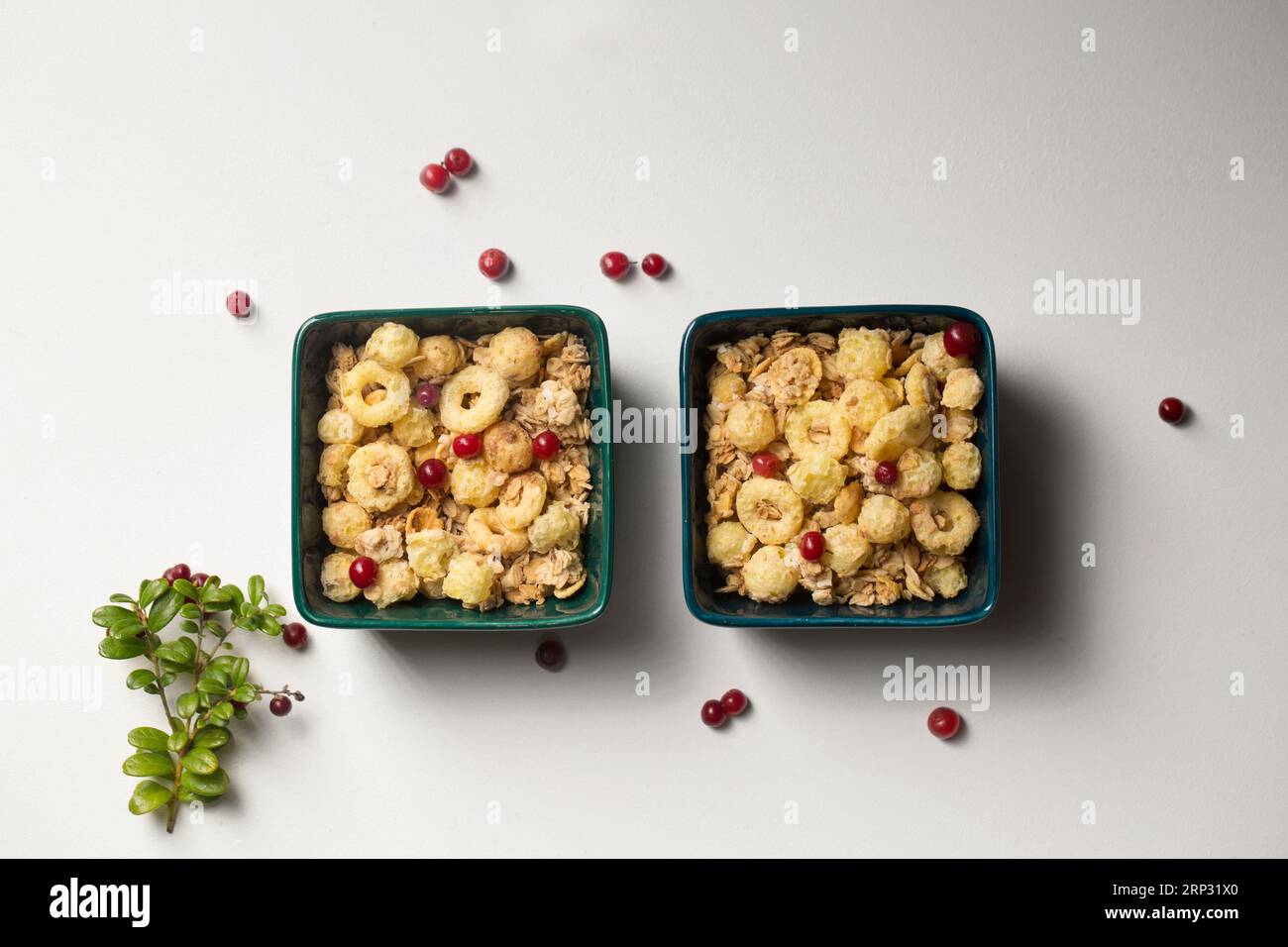 Breakfast cereal with granola and corn rings in small bowls on a white ...