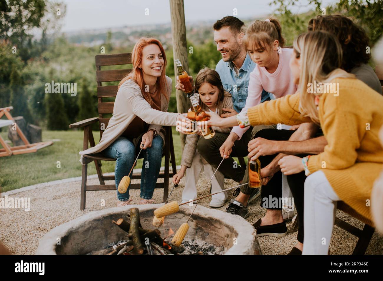 Group of friends having good time and baking corns in the house ...
