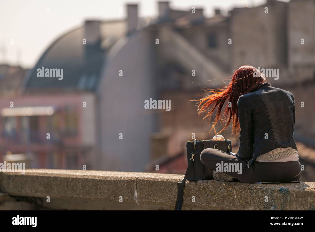 the wind swaying the red hair of a woman bathed in the rays of the ...