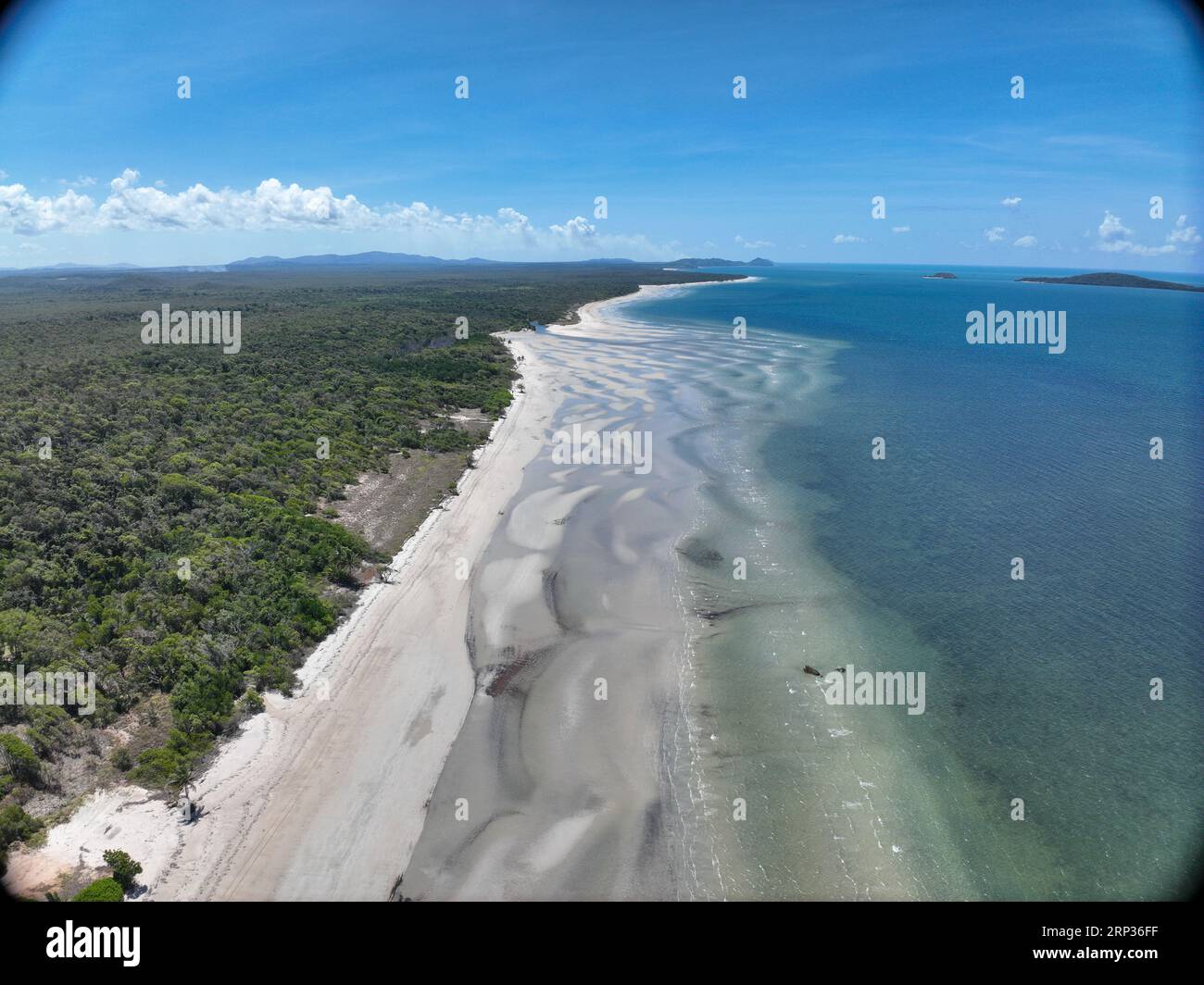 Aerial view of white rippling sandy beach and blue clear water in ...