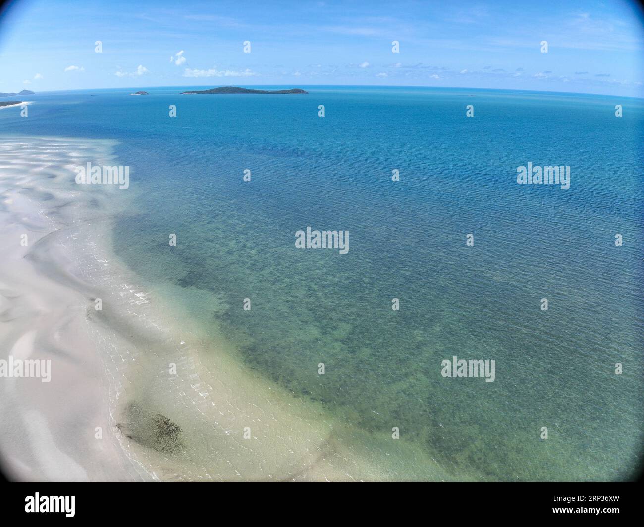 Aerial view of white rippling sandy beach and blue clear water in ...