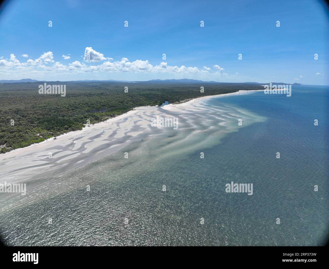 Aerial view of white rippling sandy beach and blue clear water in ...