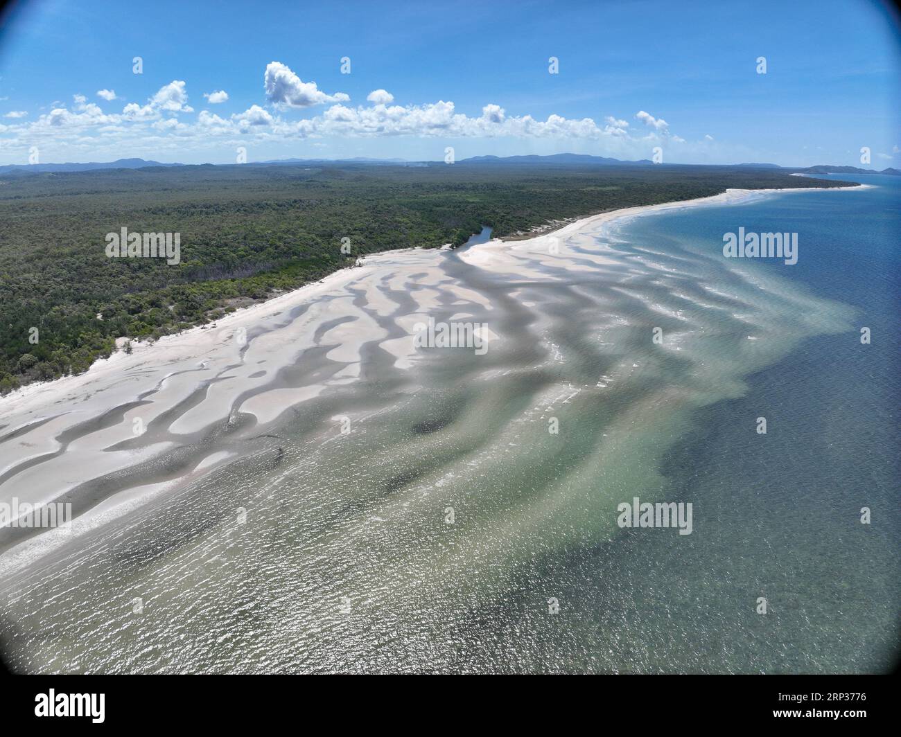 Aerial view of white rippling sandy beach and blue clear water in ...