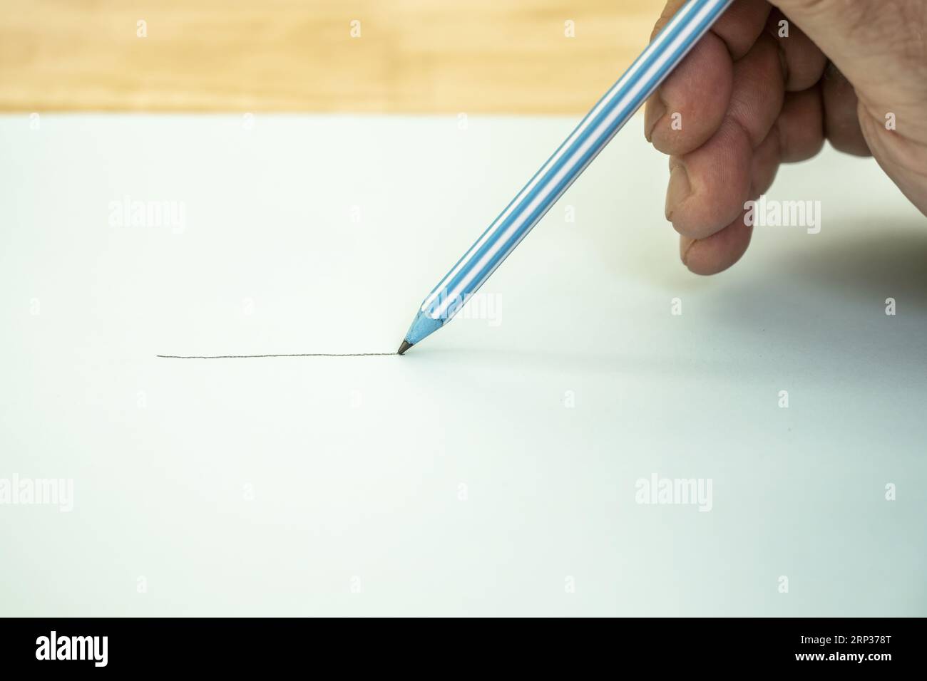 A man's hand painting a line with a graphite pencil Stock Photo - Alamy