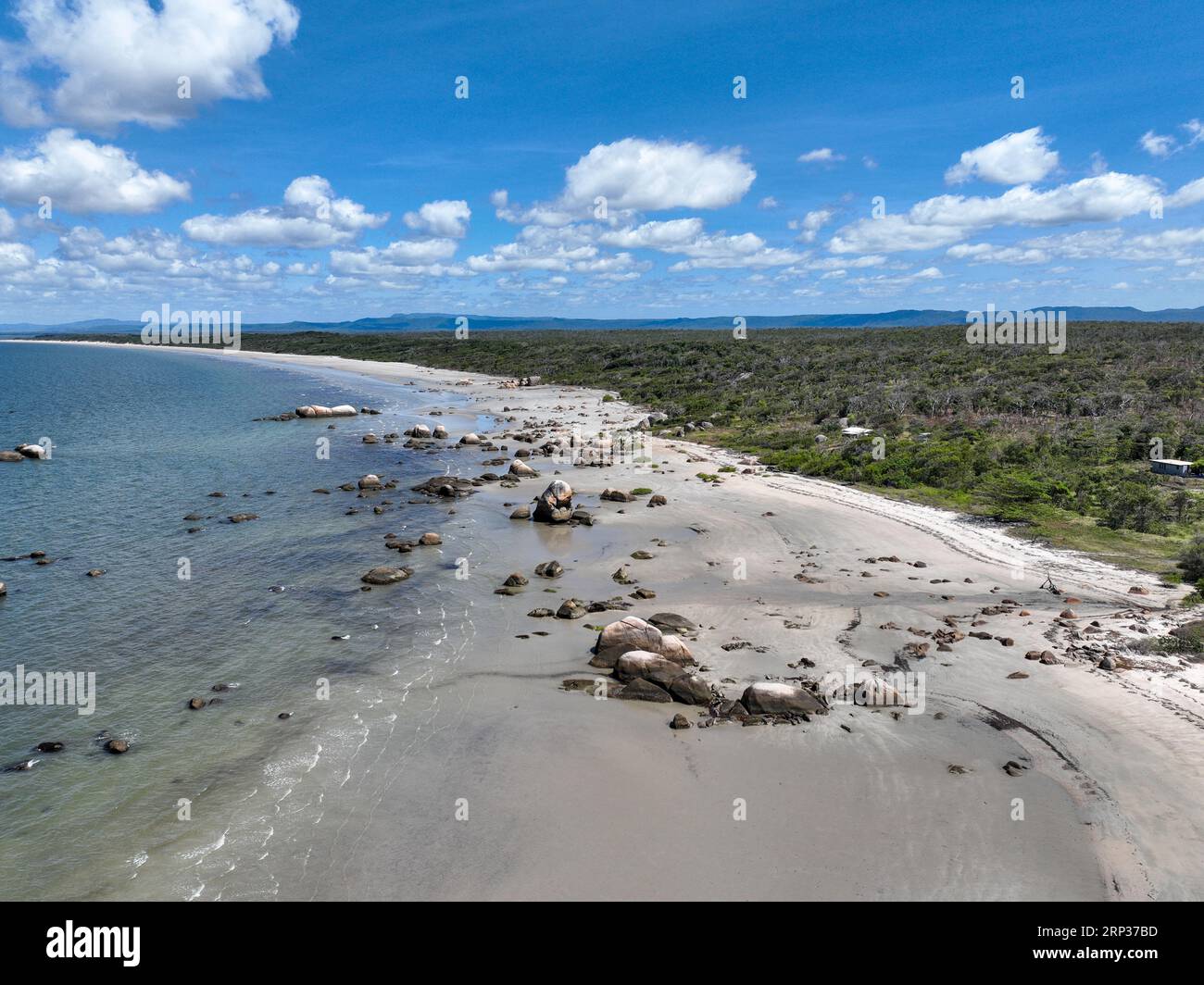 Aerial view of white rippling sandy beach and blue clear water in ...
