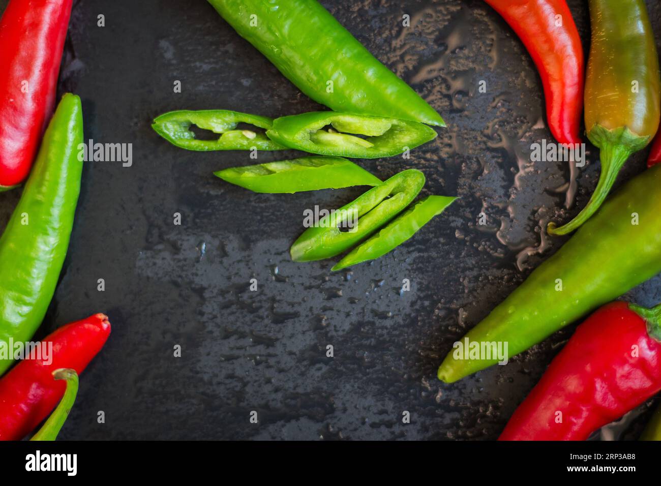 Red hot chilli peppers on black board with copy space. Heap of red and ...