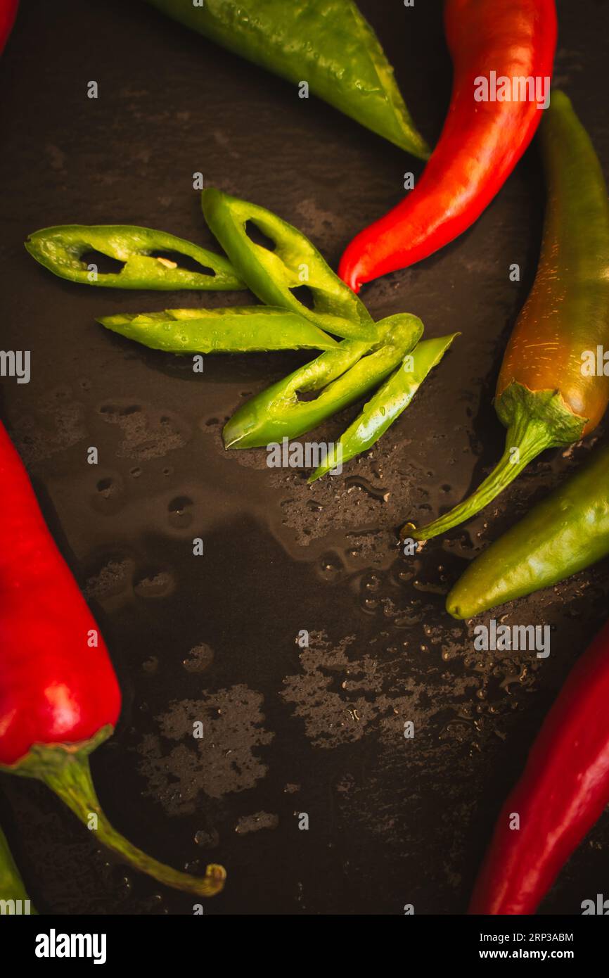 Red hot chilli peppers on black board with copy space. Heap of red and ...