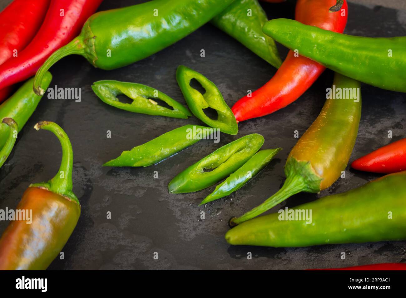Red hot chilli peppers on black board with copy space. Heap of red and ...