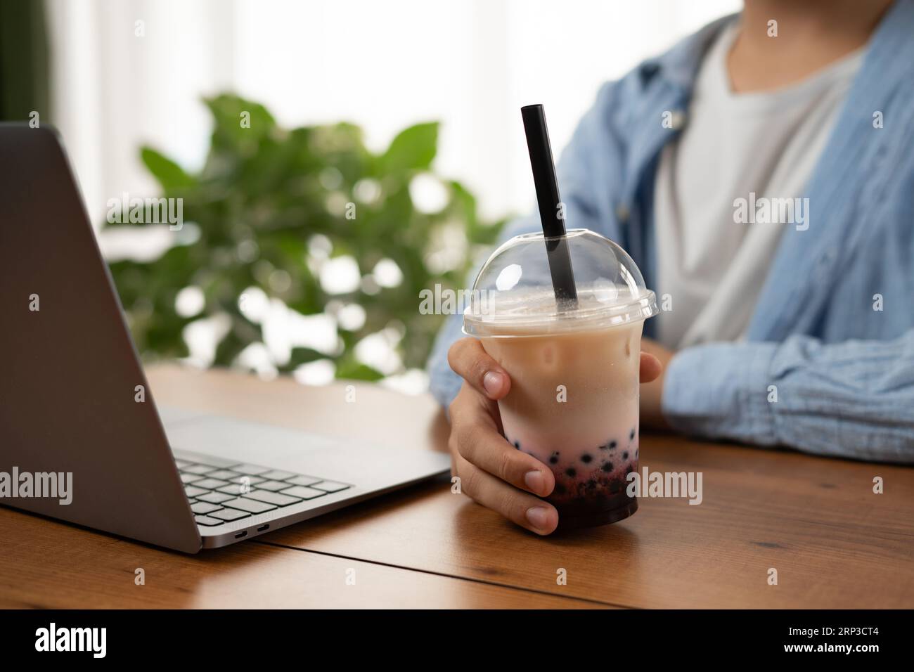 Asian young man working use laptop computer and drink bubble tea in ...