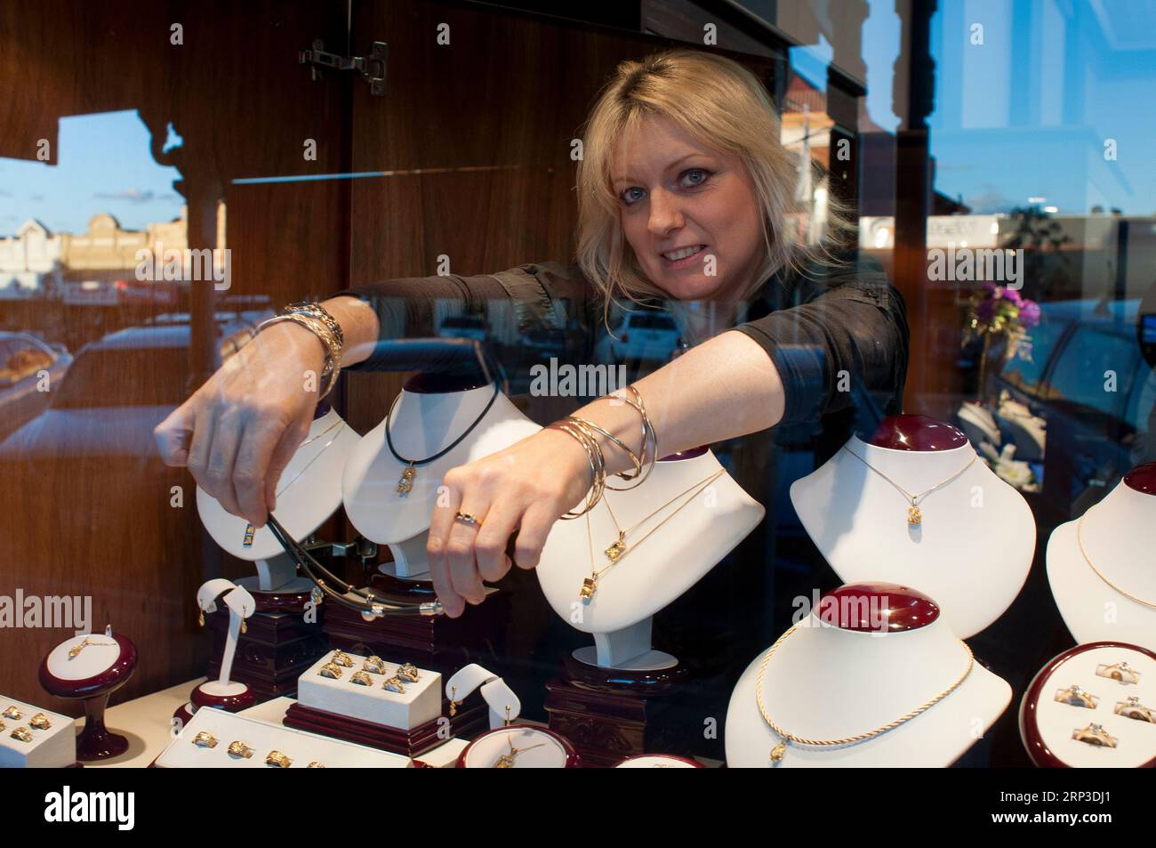 Young woman window dressing a jewellery store window in Hannan Street ...