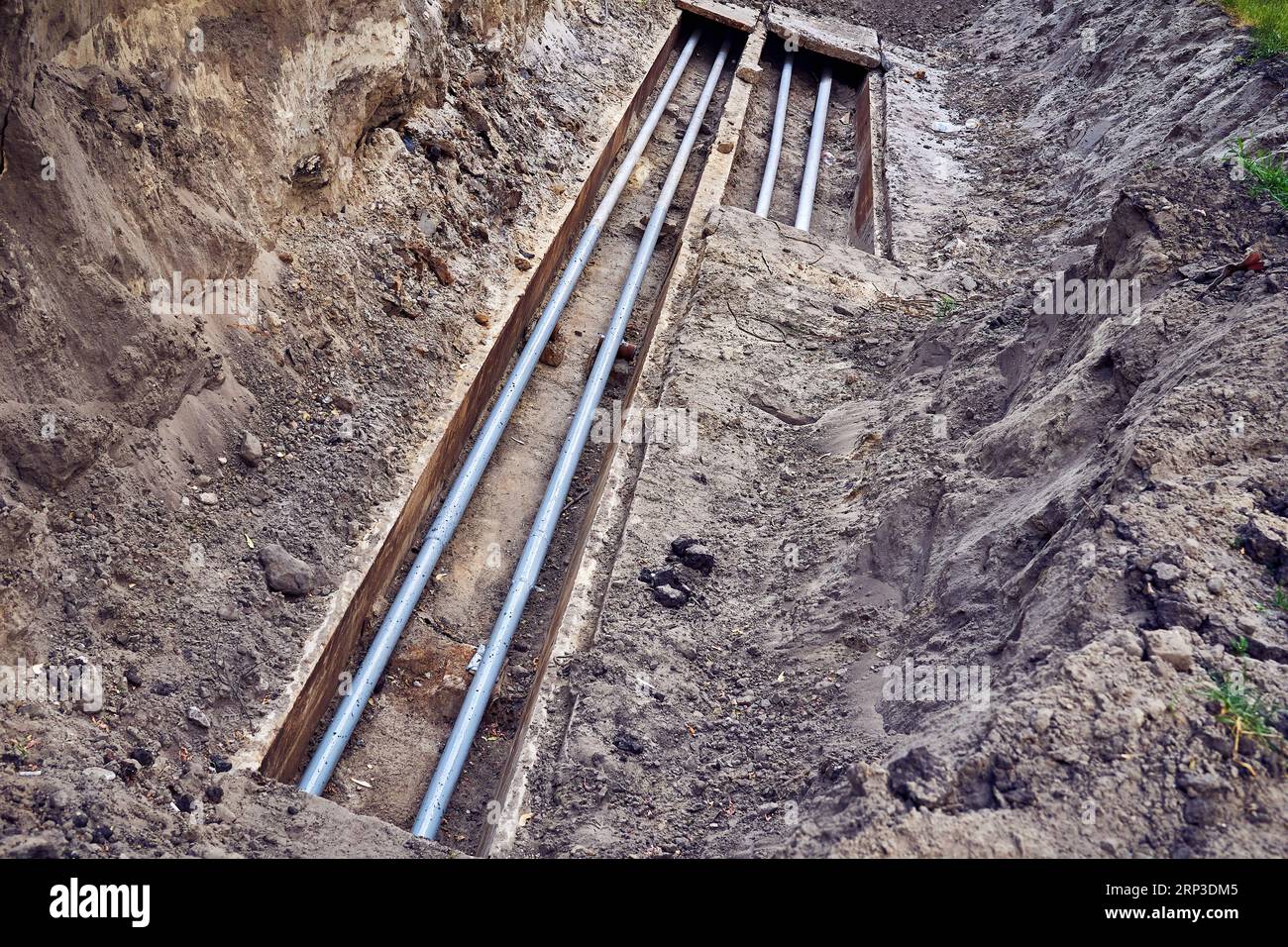 Excavated pit with plastic plumbing sewage pipes for repair and ...