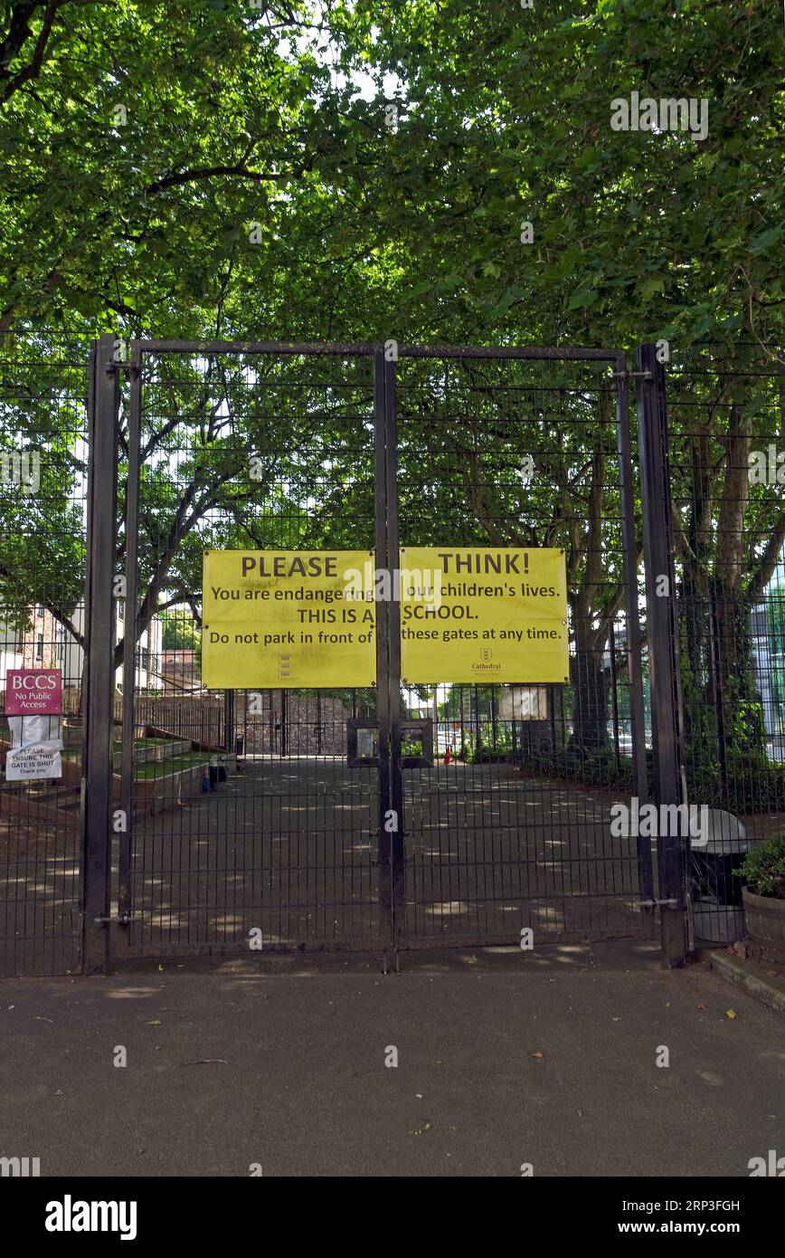 School car park with high fence and gates closed with yellow no parking ...