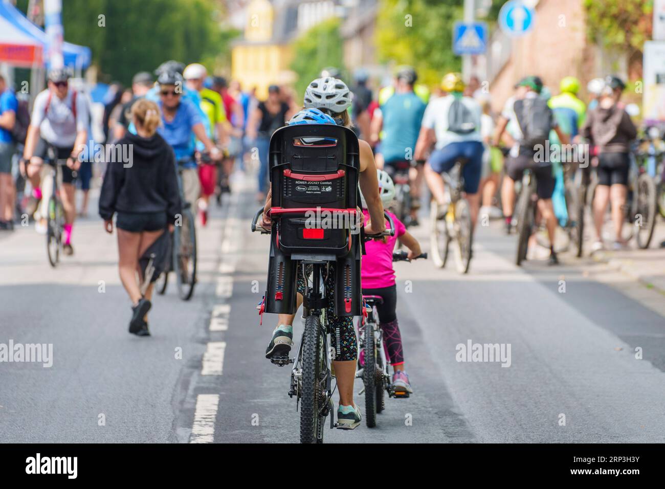 Gelnhausen, Germany. 03rd Sep, 2023. A woman rides with two children on ...