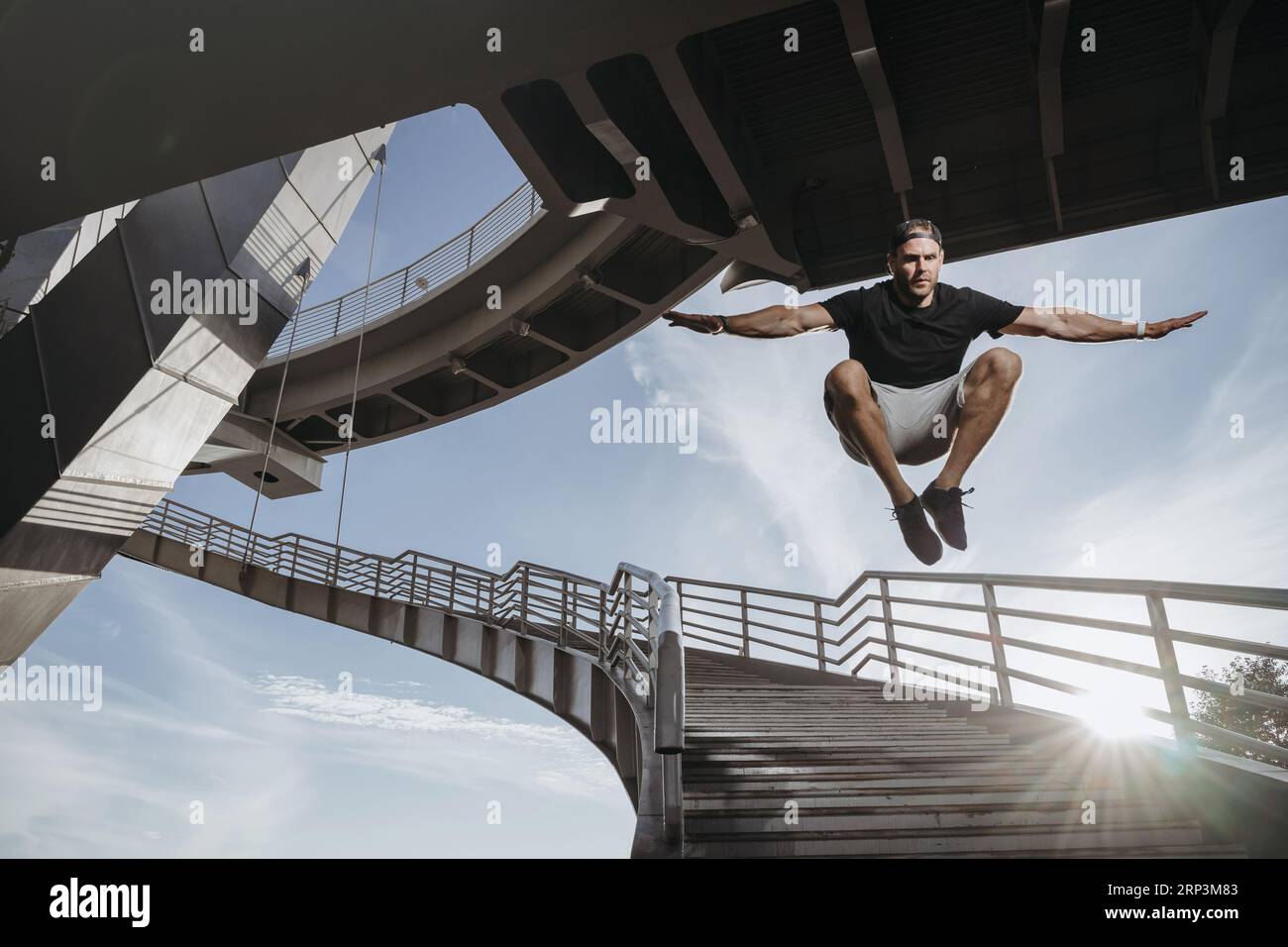 Freerunning athlete doing beautiful jump from bridge. Feelling freedom ...