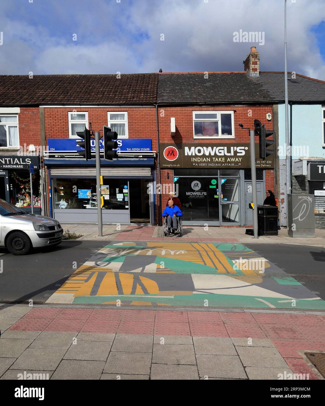 Man in a wheelchair waits at an unusually designed pedestrian crossing ...