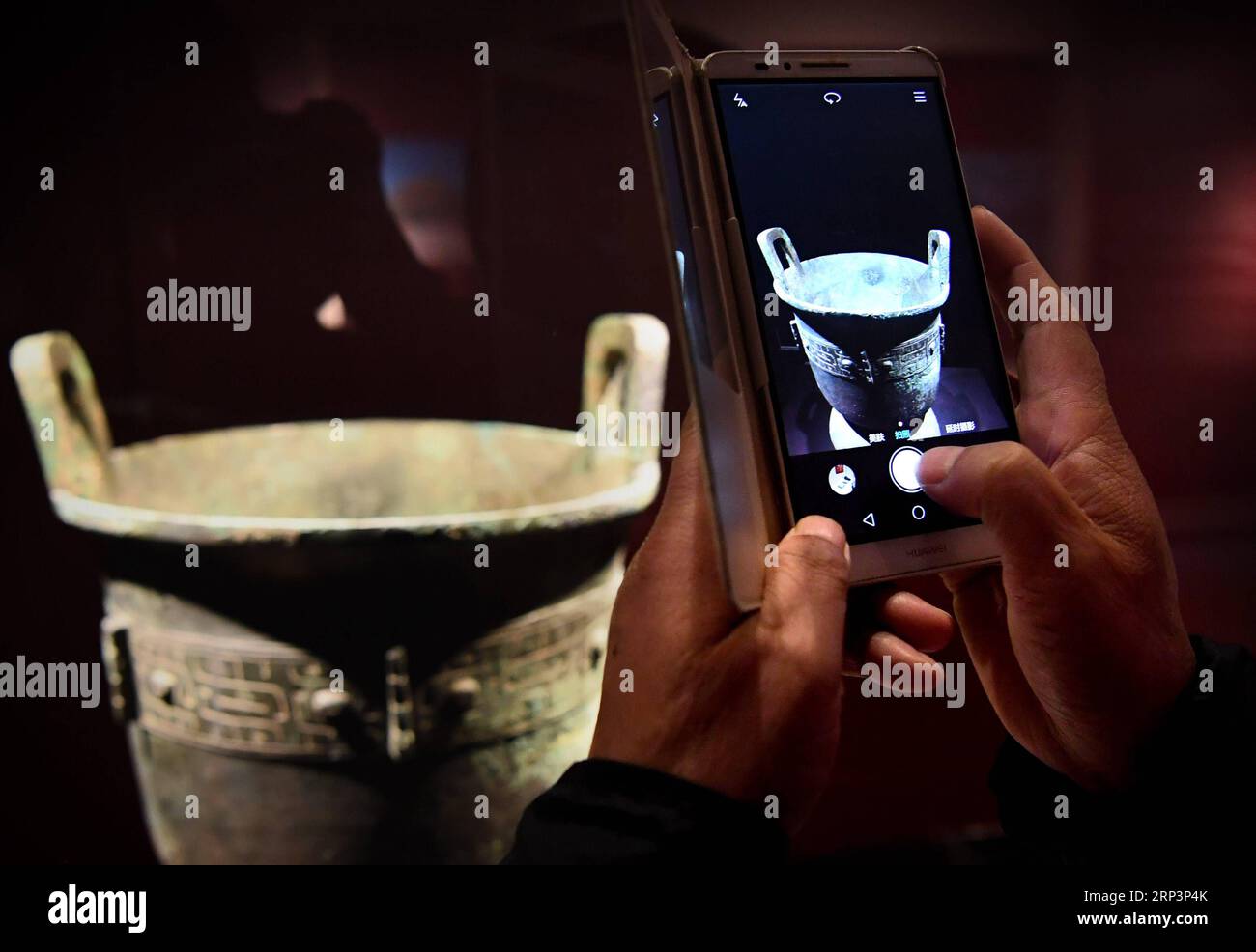 (181013) -- ANYANG, Oct. 13, 2018 -- A visitor takes photos of a bronze ...
