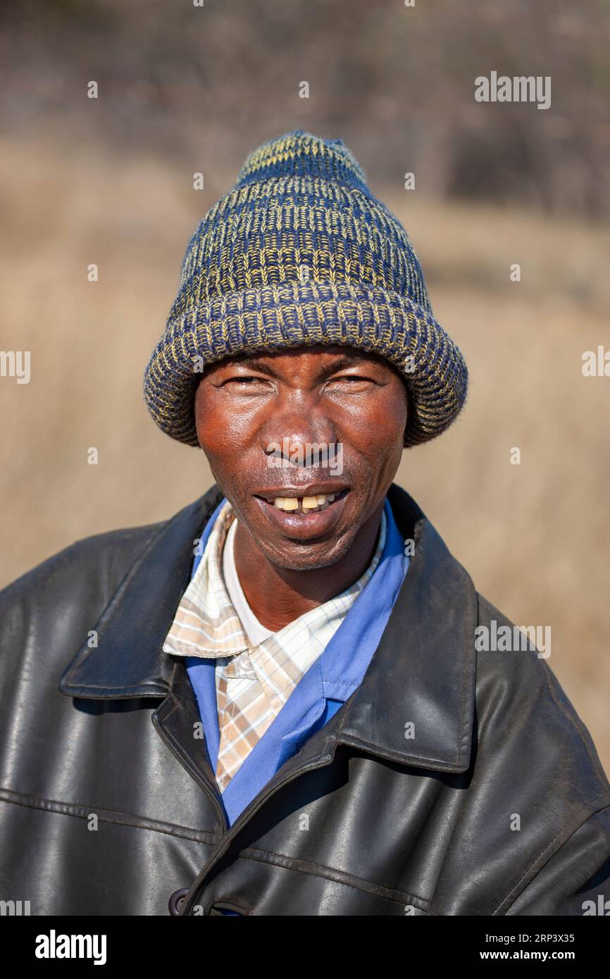african villager with a beanie and leather jacket, portrait outdoors in ...