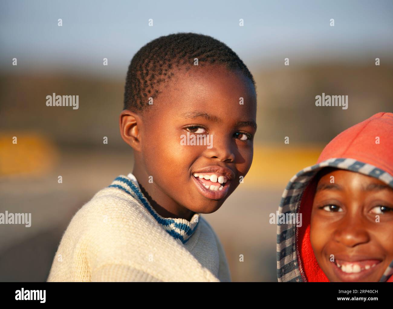 outdoor portrait of an happy child in an african village with a large ...