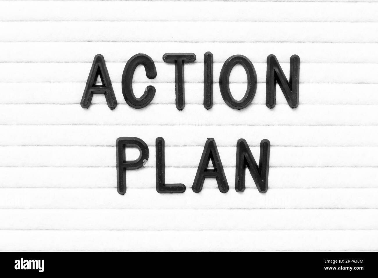 Black color letter in word action plan on white felt board background ...