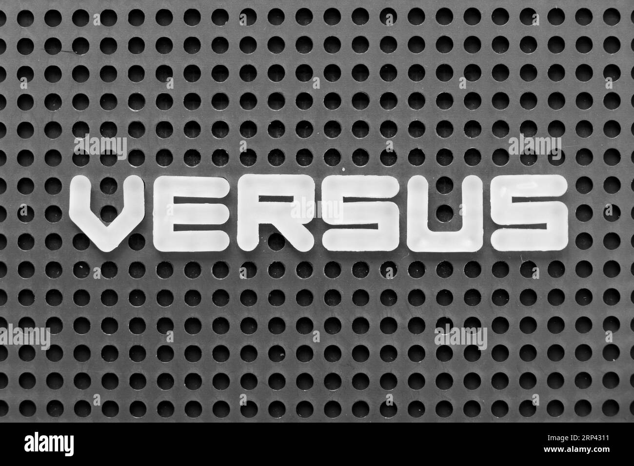 White alphabet letter in word versus on black pegboard background Stock ...