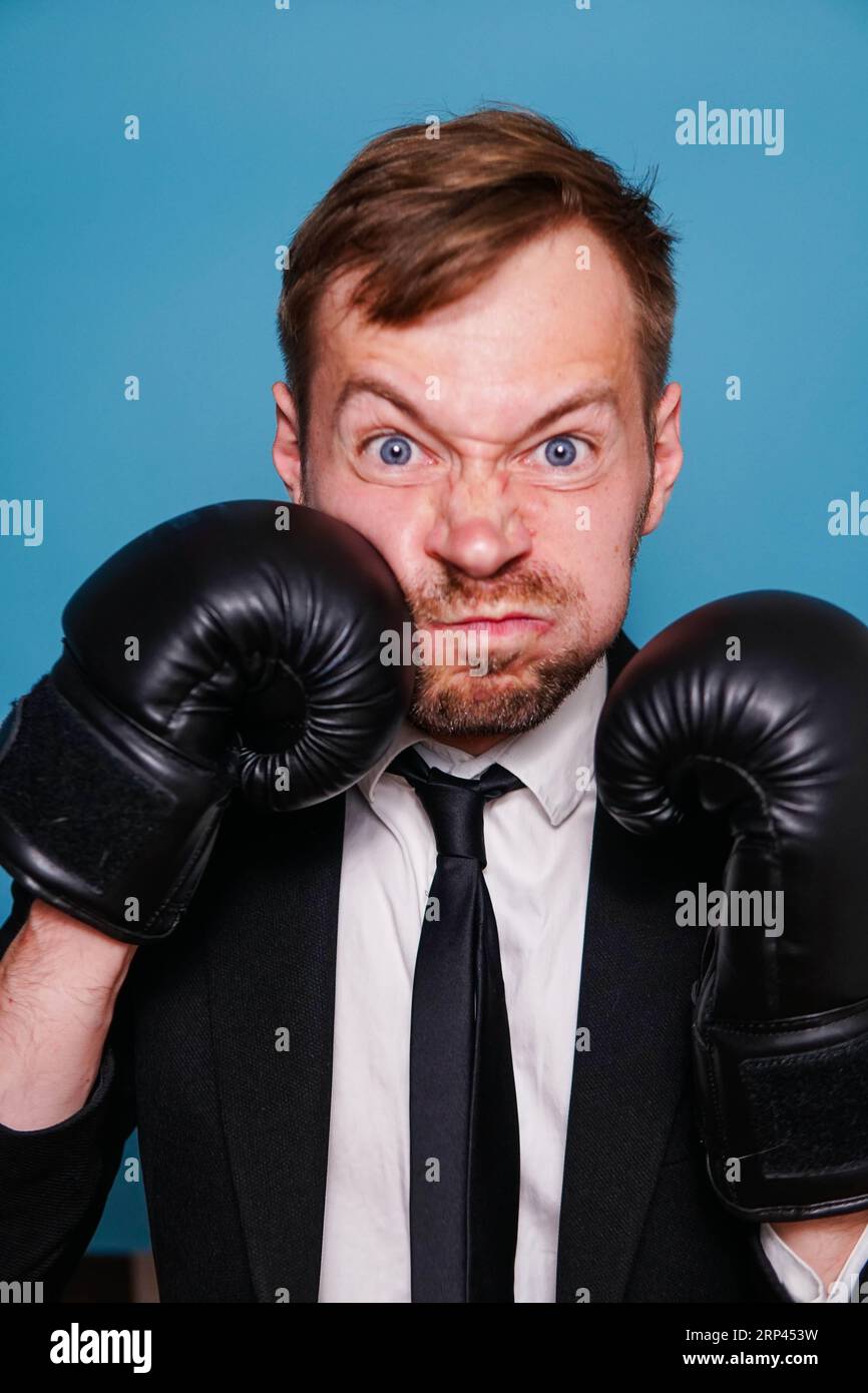 Stressed mad male businessman in black suit standing wears boxing ...