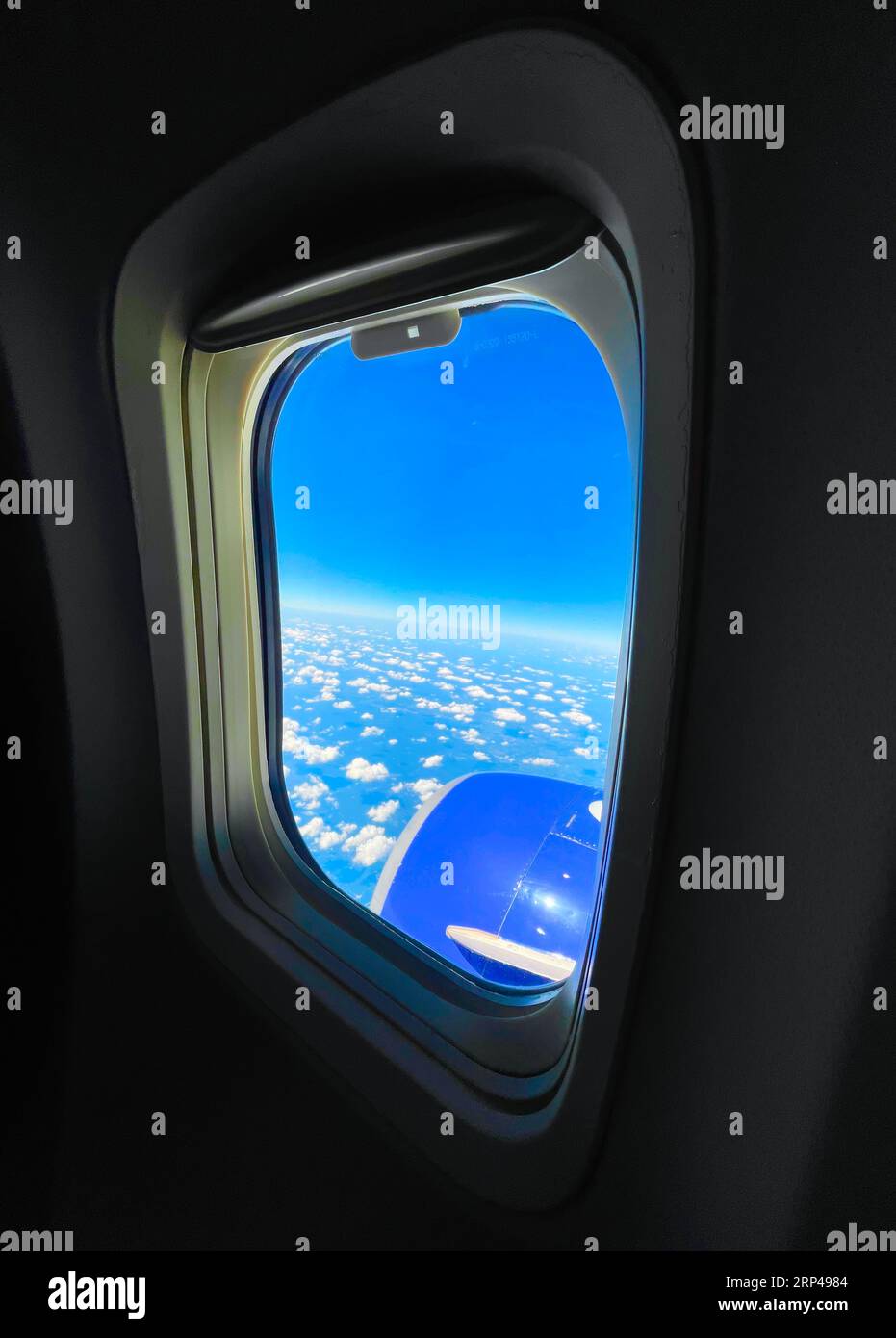 Iconic field of puffy clouds viewed from airplane window. A jet engine ...