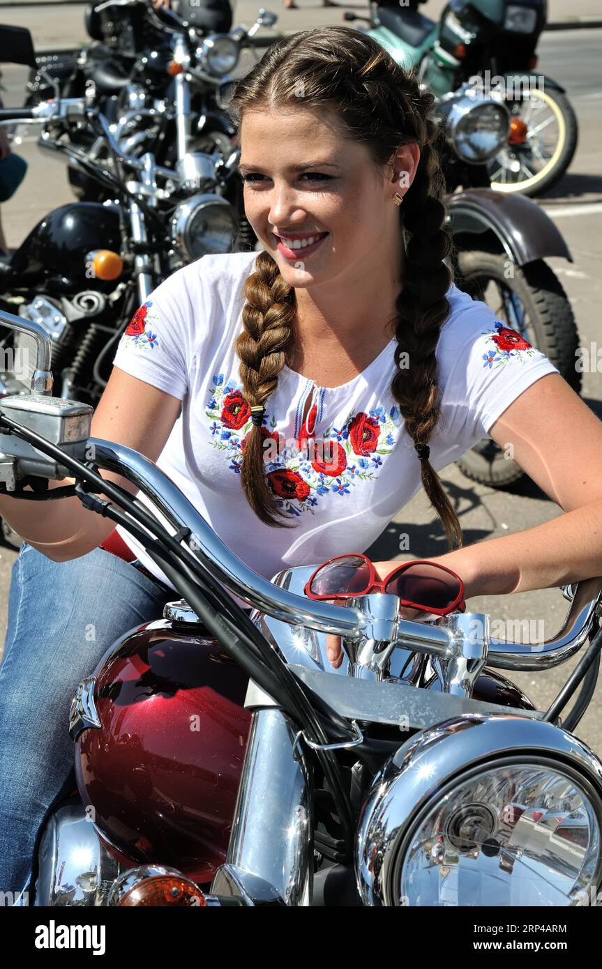 attractive biker woman sitting on her motorcycle at the motorbike show ...